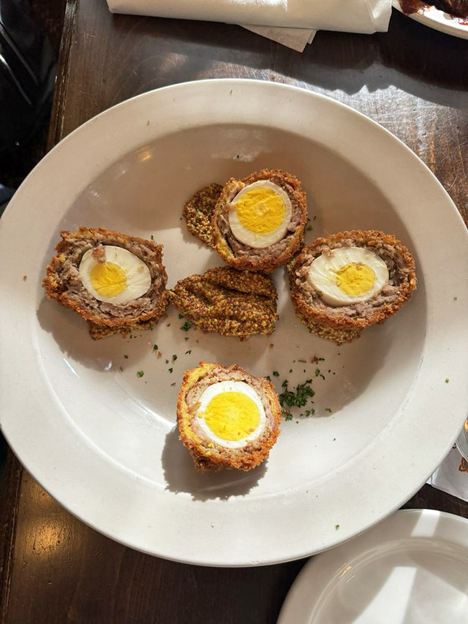Scotch eggs—where breakfast meets engineering. Hard-boiled eggs wrapped in sausage, breaded, and fried into little orbs of protein perfection.