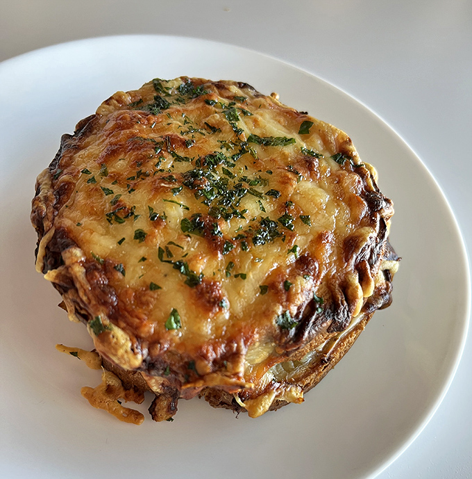 A shepherd's pie that appears to have been kissed by the gods of cheese. The herbs sprinkled on top aren't garnish—they're a crown.