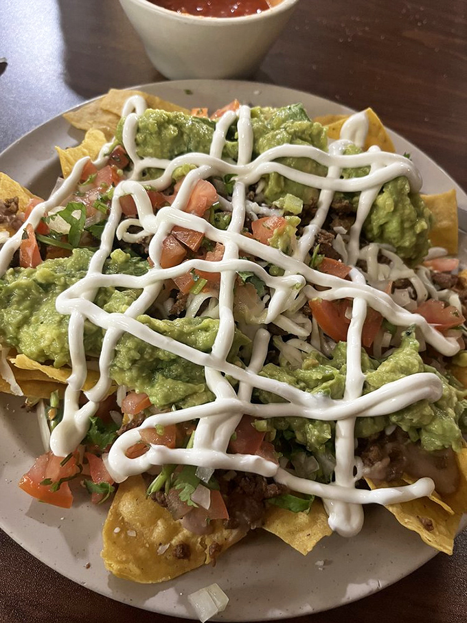 Loaded nachos that refuse to cut corners. That lattice of sour cream isn't just for show—it's the finishing touch on a mountain of flavor.