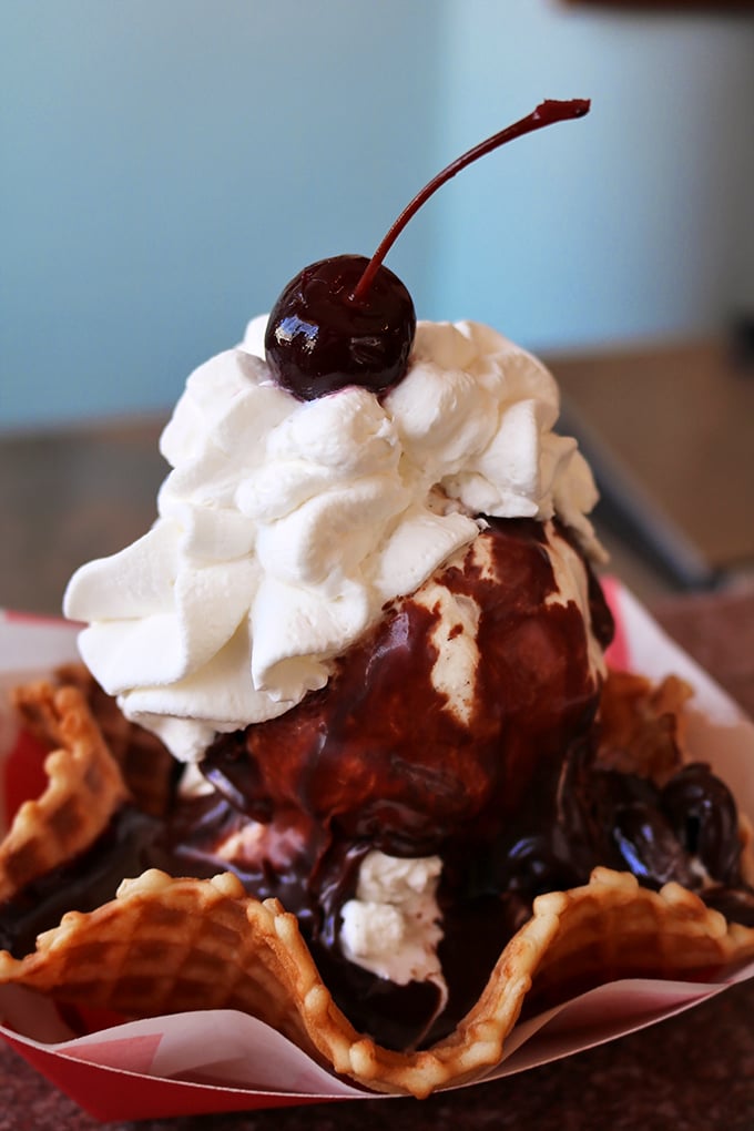 Ice cream nestled in a waffle cone, crowned with hot fudge and a cherry—proof that sometimes the universe does, in fact, love us back.