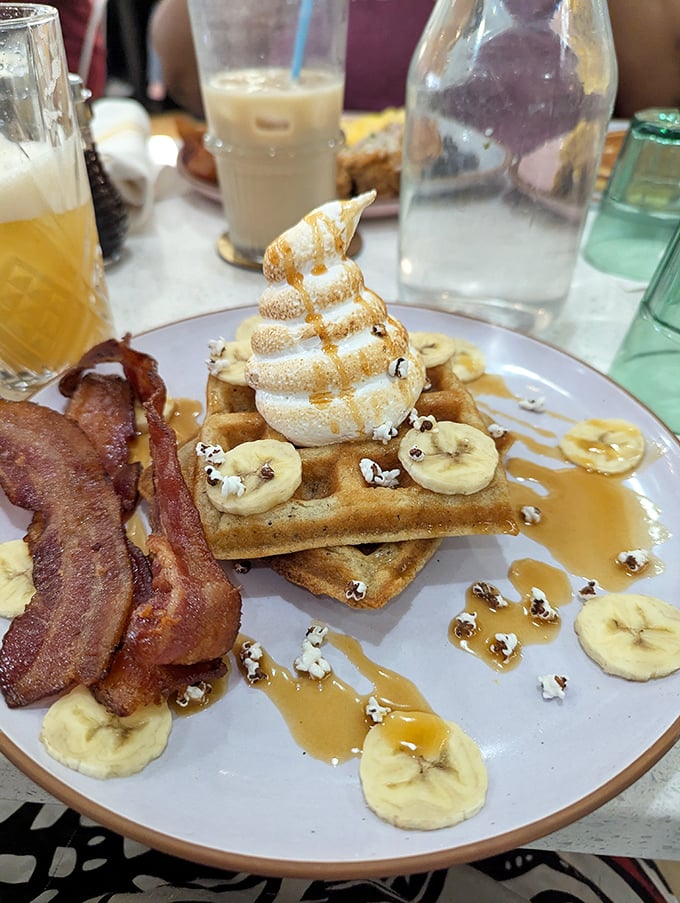 Breakfast nirvana: waffles topped with whipped cream, banana slices, and maple syrup, with bacon as the salty counterpoint to all that sweet. 