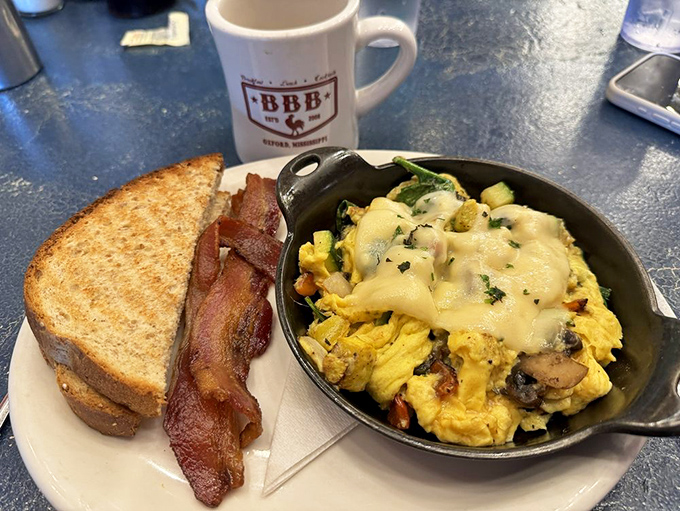 This skillet creation is what breakfast dreams are made of—eggs, veggies, and cheese in perfect harmony. The toast stands ready for dipping duty.
