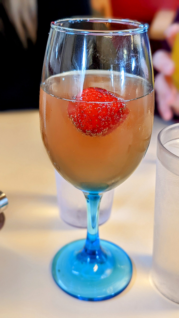 A mimosa with blue-stemmed elegance and a floating strawberry. It's not just a brunch cocktail; it's morning optimism in liquid form.