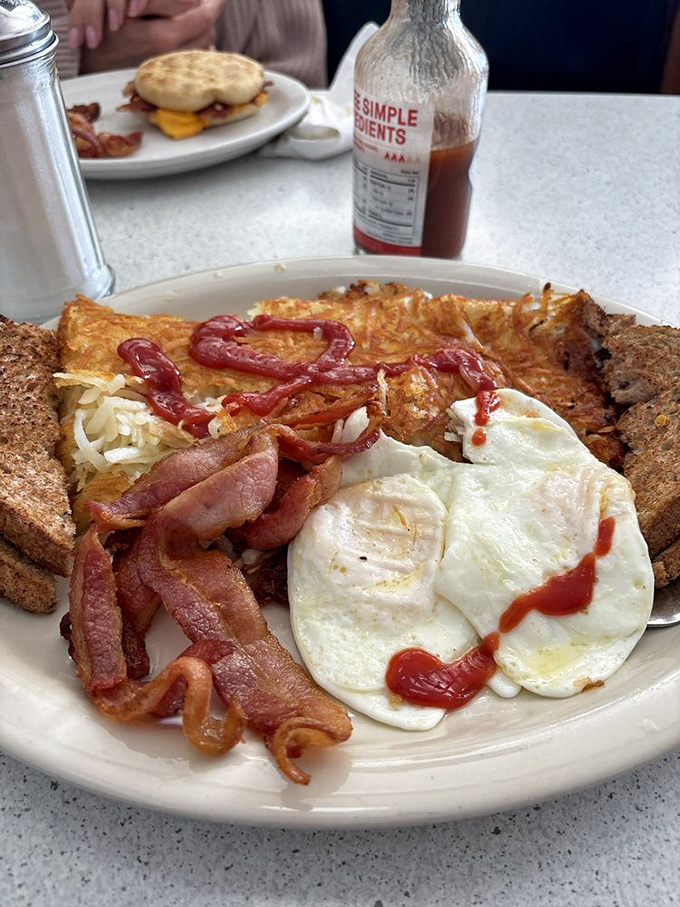 Breakfast harmony achieved – crispy bacon, perfectly fried eggs, and toast ready to soak up every last bit of yolk-y goodness.