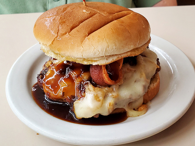Not just a burger—a masterpiece of melty cheese, savory sauce, and bacon that makes fast-food chains weep with inadequacy. Worth every napkin you'll need.