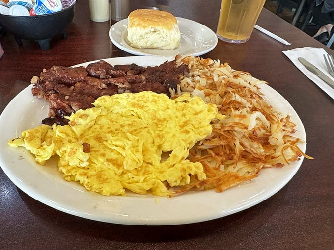 The holy trinity of diner breakfast: perfectly crisped corned beef hash, fluffy scrambled eggs, and a biscuit that could make a Southerner weep with joy.