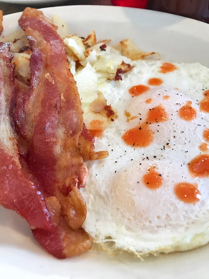 The breakfast purist's delight—perfectly cooked eggs with that vibrant sunset yolk, crispy bacon, and hash browns crisped to precise perfection.