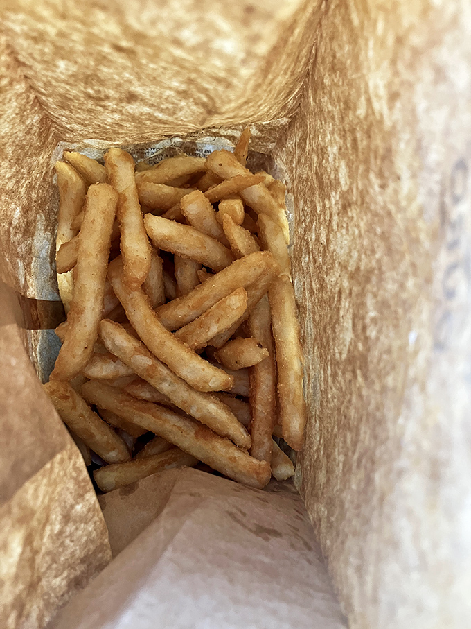 French fries hiding in their paper bag like gold in Fort Knox – crispy, golden, and worth every calorie-counting exception you'll make.