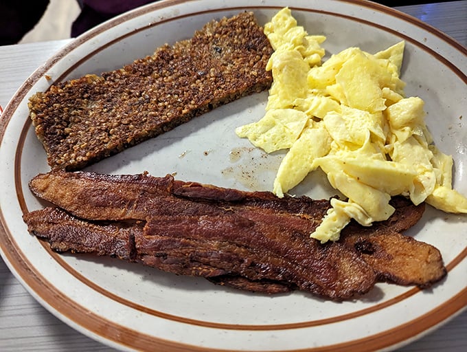 Breakfast's holy trinity: crispy bacon, farm-fresh scrambled eggs, and goetta—Kentucky's gift to the breakfast world. Simple perfection on a plate.
