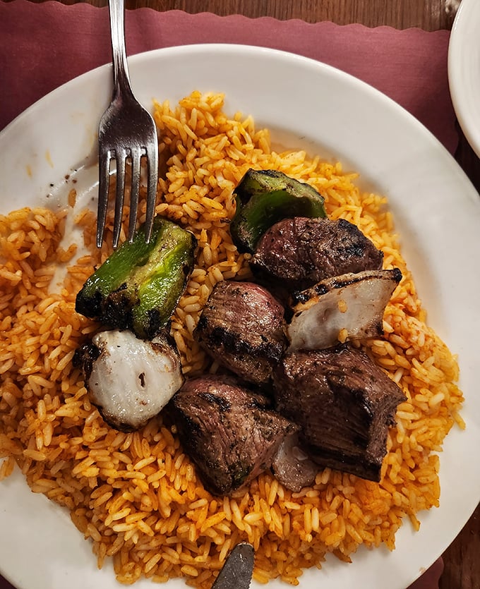 The beef tenderloin kabob resting on a bed of seasoned rice—proof that sometimes the simple things in life are the most extraordinary.