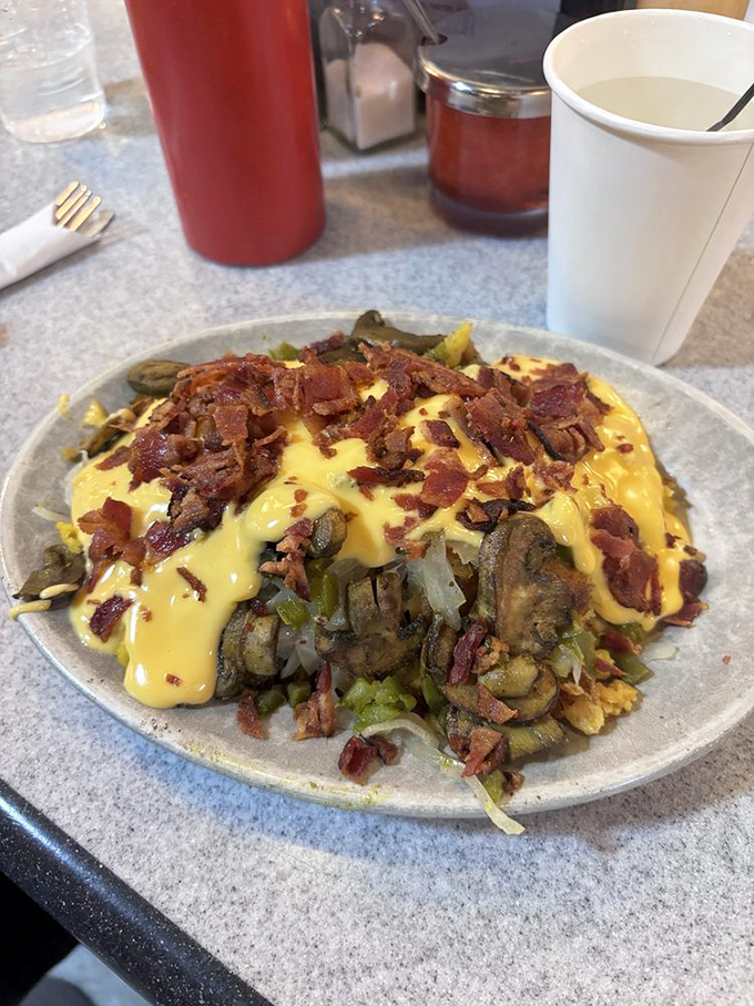 An omelet that's not messing around. Loaded with veggies, draped in cheese, and crowned with bacon—breakfast royalty on a simple plate.