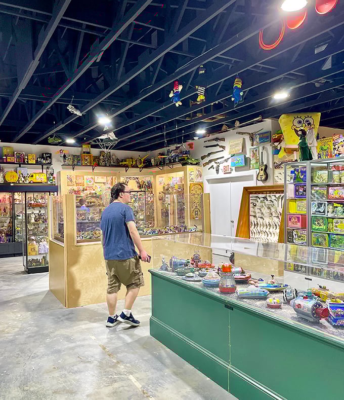 Treasure hunting in progress as a visitor browses display cases. The museum's layout invites wandering between glass-enclosed memories from decades past.