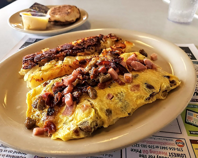 This isn't just an omelet—it's a protein-packed canvas where ham, mushrooms and cheese perform a beautiful morning ballet. Paired with crispy bacon, it's breakfast nirvana.