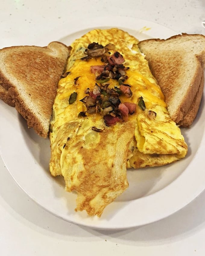 An omelet that doesn't just contain ingredients – it celebrates them. Those ham bits and peppers are doing a happy dance under melted cheese.