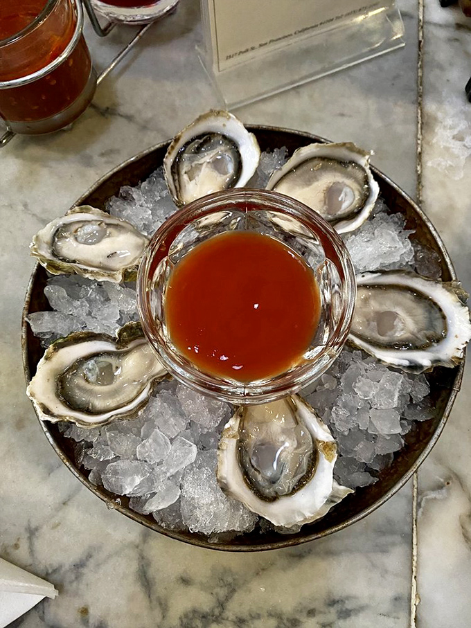 These oysters aren't just served—they're presented like the jewels of the sea they are, with cocktail sauce playing the perfect supporting role.