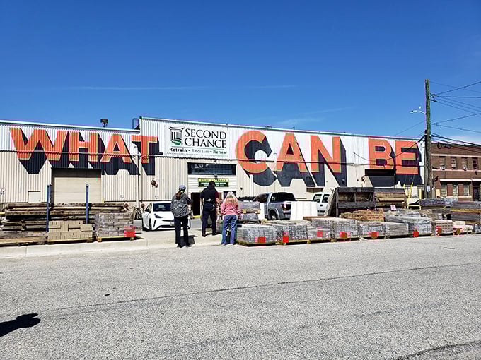 The exterior boldly proclaims "WHAT CAN BE" against a bright blue sky—a philosophical question and architectural salvage mission rolled into one.