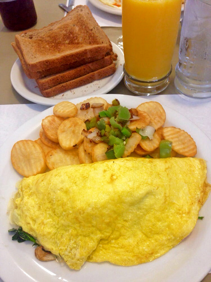 This omelet doesn't just contain spinach and mushrooms—it celebrates them in a fluffy egg embrace that would make Popeye weep with joy.