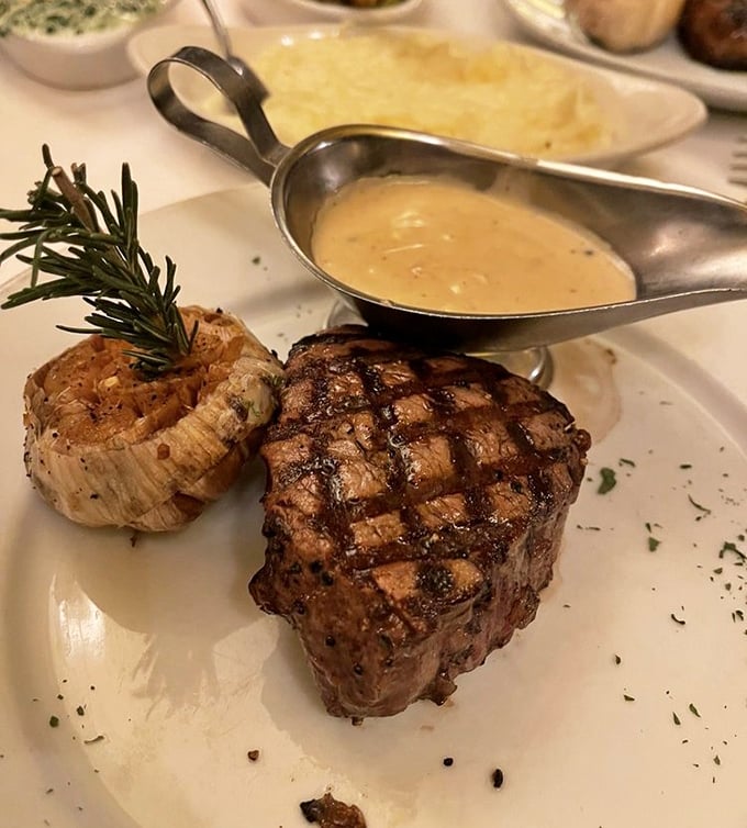 This isn't just a steak—it's a masterclass in meat preparation, complete with a rosemary sprig standing guard like a tiny aromatic sentinel.