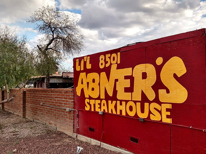 Lil Abner's rustic red exterior isn't trying to impress anyone—the mesquite-grilled masterpieces inside do all the talking.