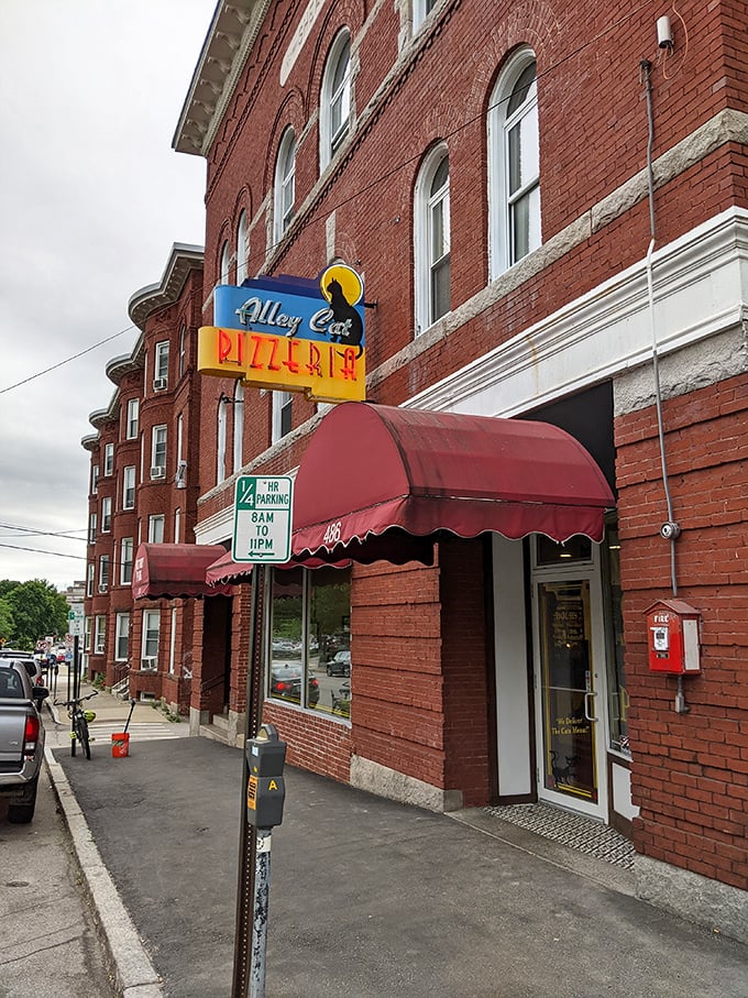 That red awning isn't just for show - it's the gateway to pizza paradise hiding in plain sight on a Manchester street corner.