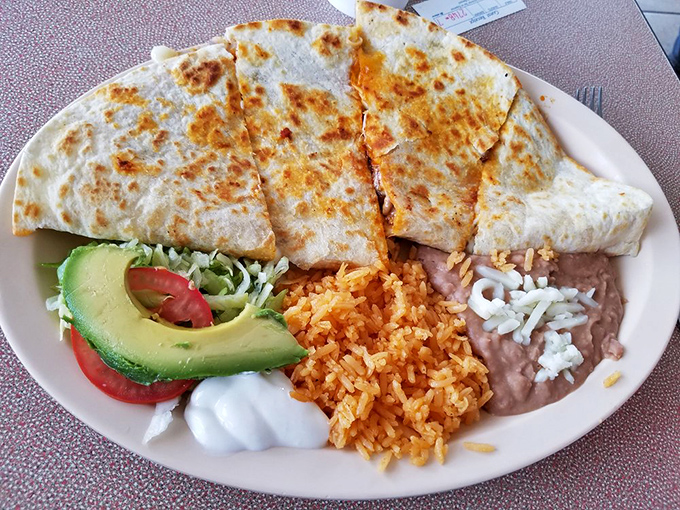Quesadillas done right—golden, crispy exterior giving way to melty cheese and savory fillings. That fresh avocado slice is the perfect cool counterpoint.