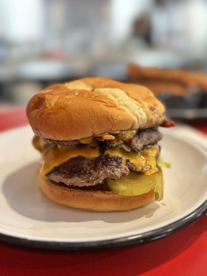 This isn't just a burger—it's a skyscraper of beef, cheese, and pickles that requires architectural planning before the first bite.