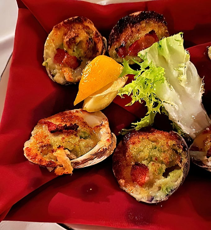 These aren't just baked clams—they're little boats of briny goodness sailing on a sea of herb butter. The lemon wedge isn't garnish, it's essential equipment.