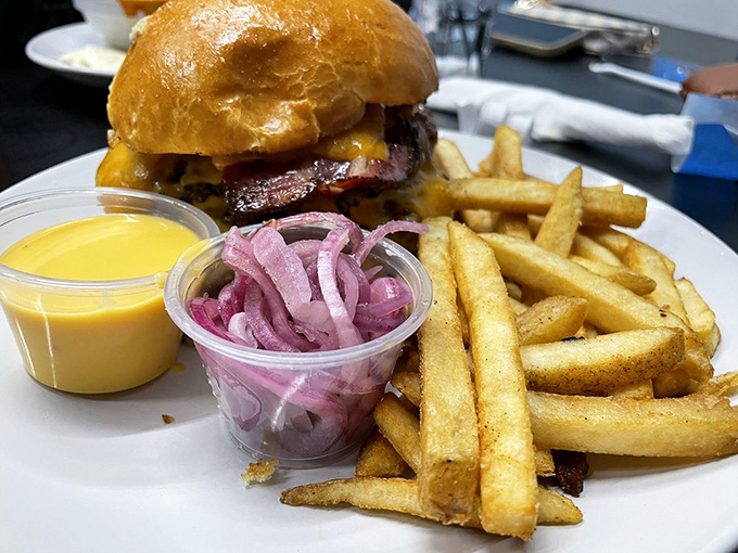 This burger isn't just lunch—it's therapy on a plate, complete with golden fries and pickled red onions for that perfect tangy contrast.