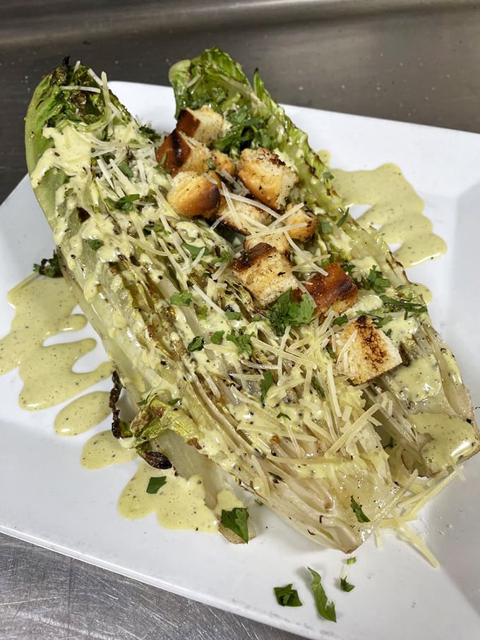 Caesar salad reimagined as art—romaine hearts grilled to smoky perfection. Parmesan snowfall and croutons that actually deserve the name.
