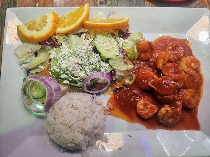 A plate that celebrates color as much as flavor – spicy shrimp, fresh vegetables, and rice arranged like an edible work of art.