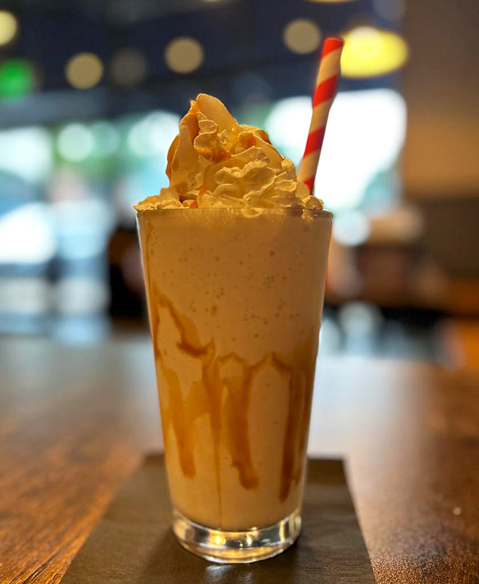 Caramel cascading down glass walls like a sweet waterfall. This isn't just a milkshake—it's dessert with drinking privileges.