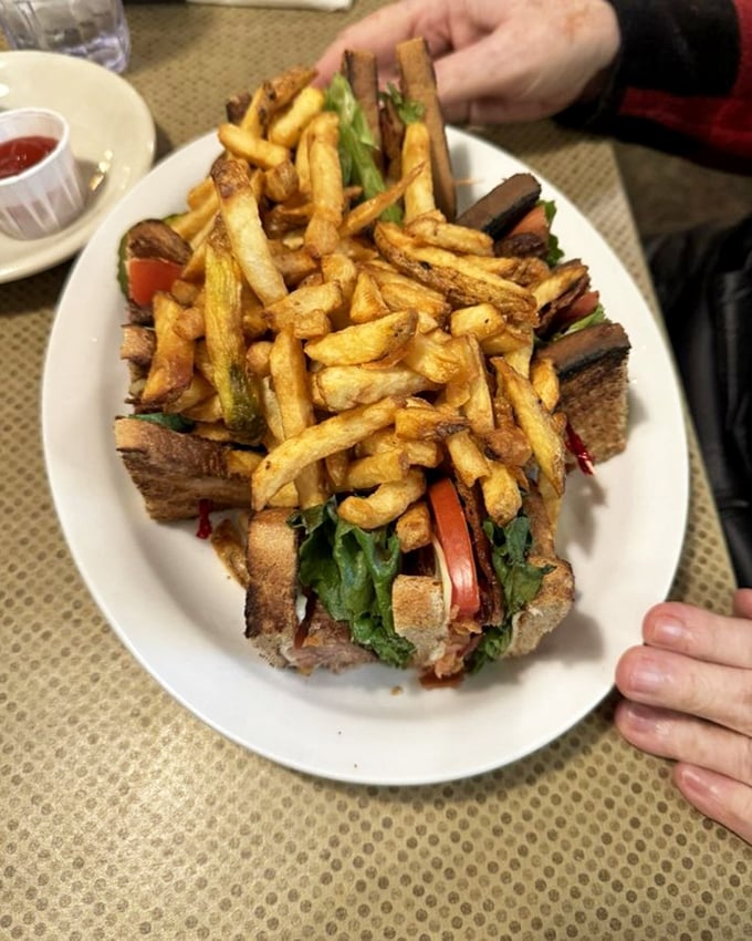 The club sandwich reimagined—stacked higher than my weekend reading pile and requiring both hands, serious concentration, and zero regrets.