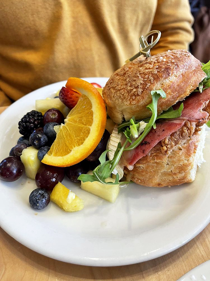 A sandwich worthy of its own ZIP code – house-baked bread, fresh greens, and a side of fruit that isn't just an afterthought.