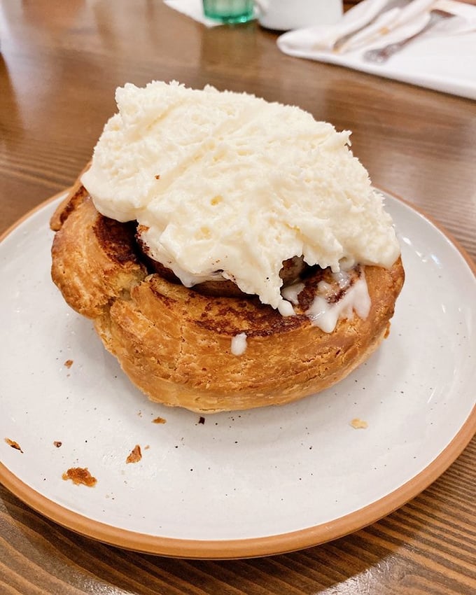 This isn't just a cinnamon roll—it's a cloud of pastry perfection with a snowcap of cream cheese that makes Monday mornings bearable again.