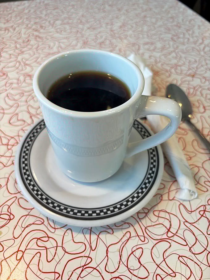 Simple pleasures: diner coffee in a white mug with that distinctive black-rimmed pattern—the universal symbol for "refills welcome."