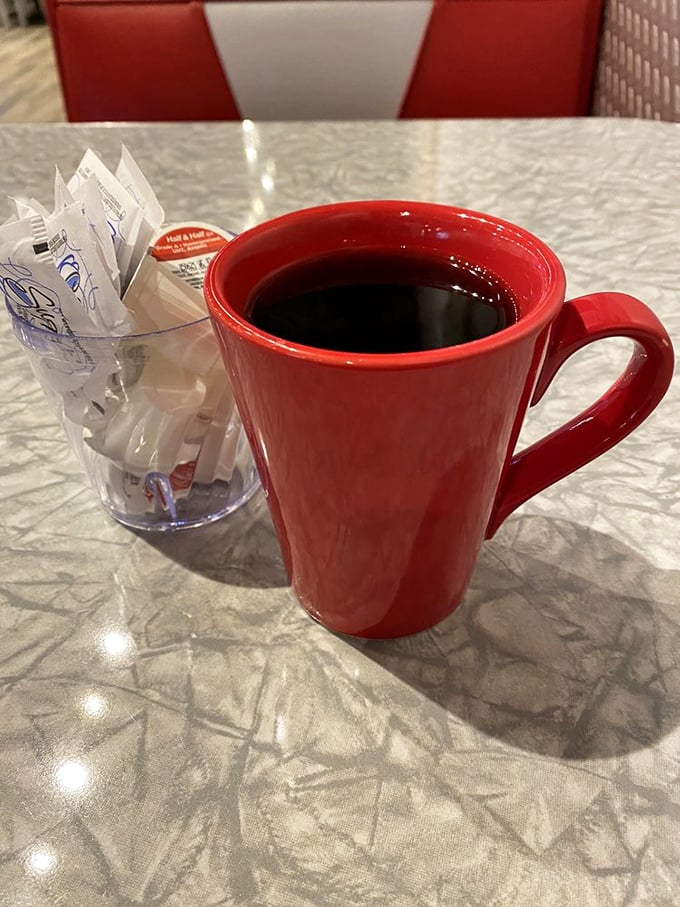 The classic red coffee mug – holding the life-giving elixir that transforms morning zombies into functioning humans since forever.