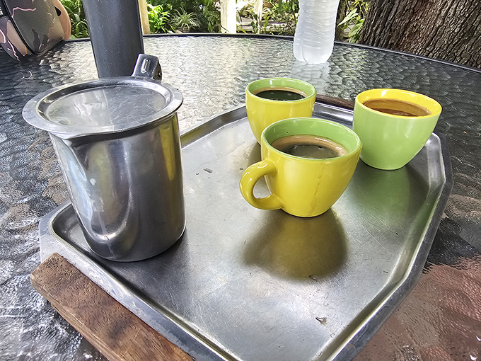 Coffee served in cheerful yellow cups on a metal tray—unpretentious, strong, and exactly what you need after that sandwich.
