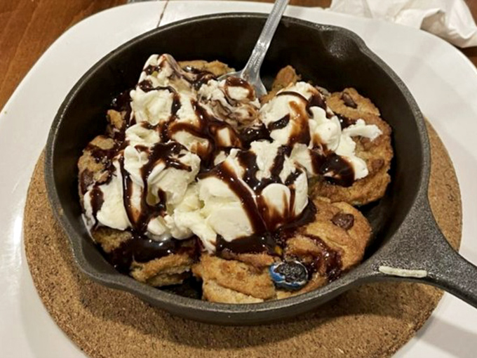 Dessert that speaks to your inner child—a warm cookie skillet topped with ice cream and chocolate drizzle. Resistance is futile, diet starts tomorrow.