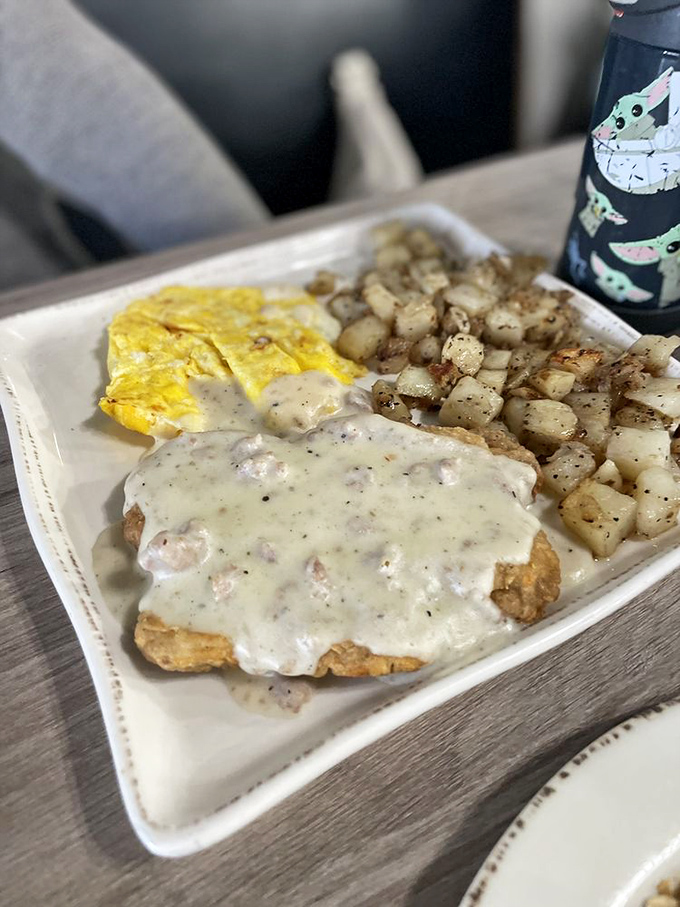 Country fried steak swimming in creamy gravy alongside golden potatoes and fluffy eggs—the breakfast equivalent of a warm hug from your favorite aunt.