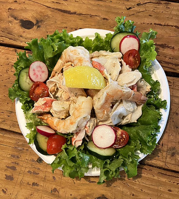 This seafood salad isn't just lunch—it's a refreshing celebration of the ocean's bounty, arranged atop crisp greens with the perfect touch of color.