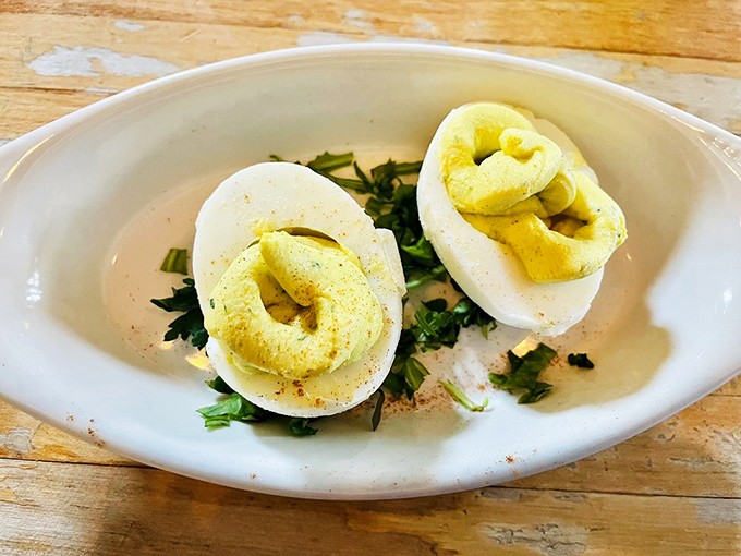 These aren't your standard picnic deviled eggs—they're a study in simplicity and perfection, dusted with paprika and fresh herbs.
