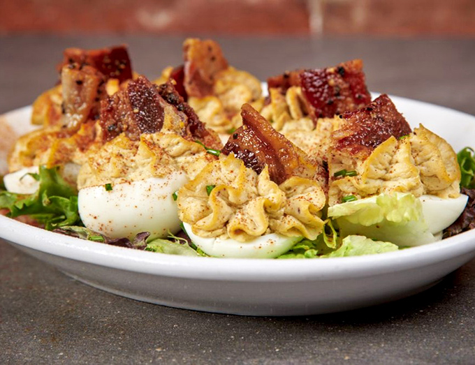Deviled eggs gone rogue with smoked pork and bacon. These aren't your grandmother's picnic eggs—unless your grandmother was secretly a culinary genius.