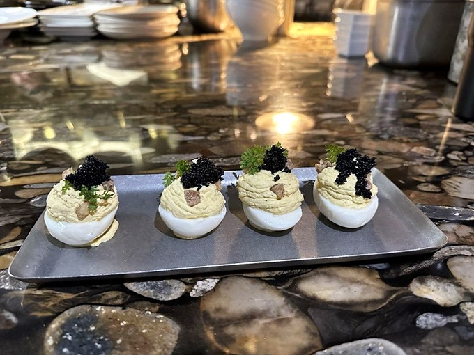 Deviled eggs wearing their Sunday best, topped with caviar. These aren't your grandmother's potluck contribution—unless Grandma was secretly a culinary rebel.