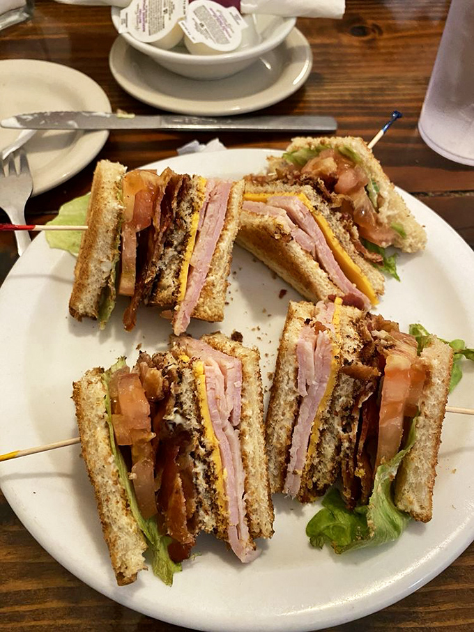 This club sandwich isn't stacked for the camera—it's built for serious eaters who understand that sometimes the perfect meal comes between two slices of bread.