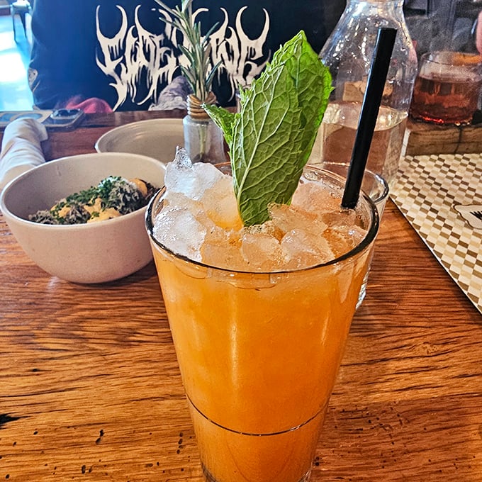 Cocktail artistry in full effect. That fresh mint leaf isn't just garnish—it's an aromatic invitation to the refreshing experience below the ice.