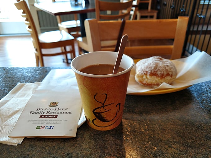 Coffee and pastry: nature's perfect pairing. This simple cup alongside a powdered treat proves some relationships are meant to last forever—or at least until the last bite.