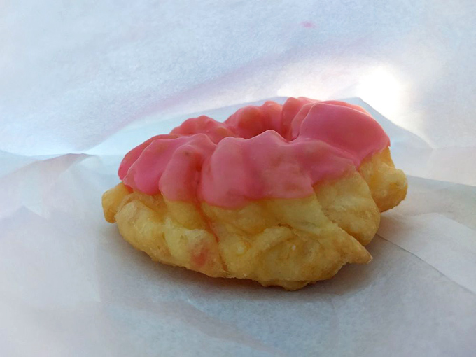 The French cruller—a golden spiral of delicate pastry topped with pink glaze—proves that sometimes beauty can indeed be eaten.