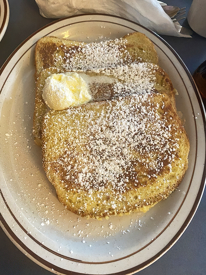 French toast dusted with powdered sugar, looking like it just got caught in the world's most delicious snowstorm.