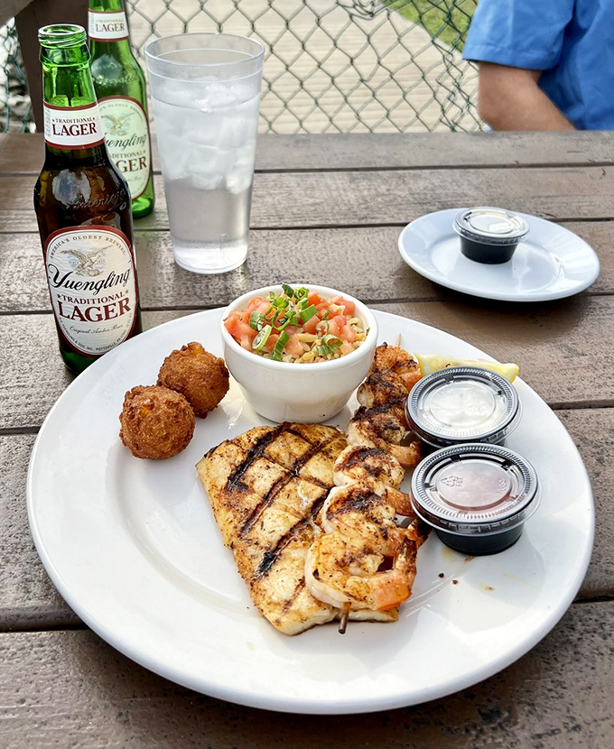 Perfectly grilled fish alongside hushpuppies and slaw—proof that sometimes the simplest preparations let the freshness of Gulf seafood shine brightest.