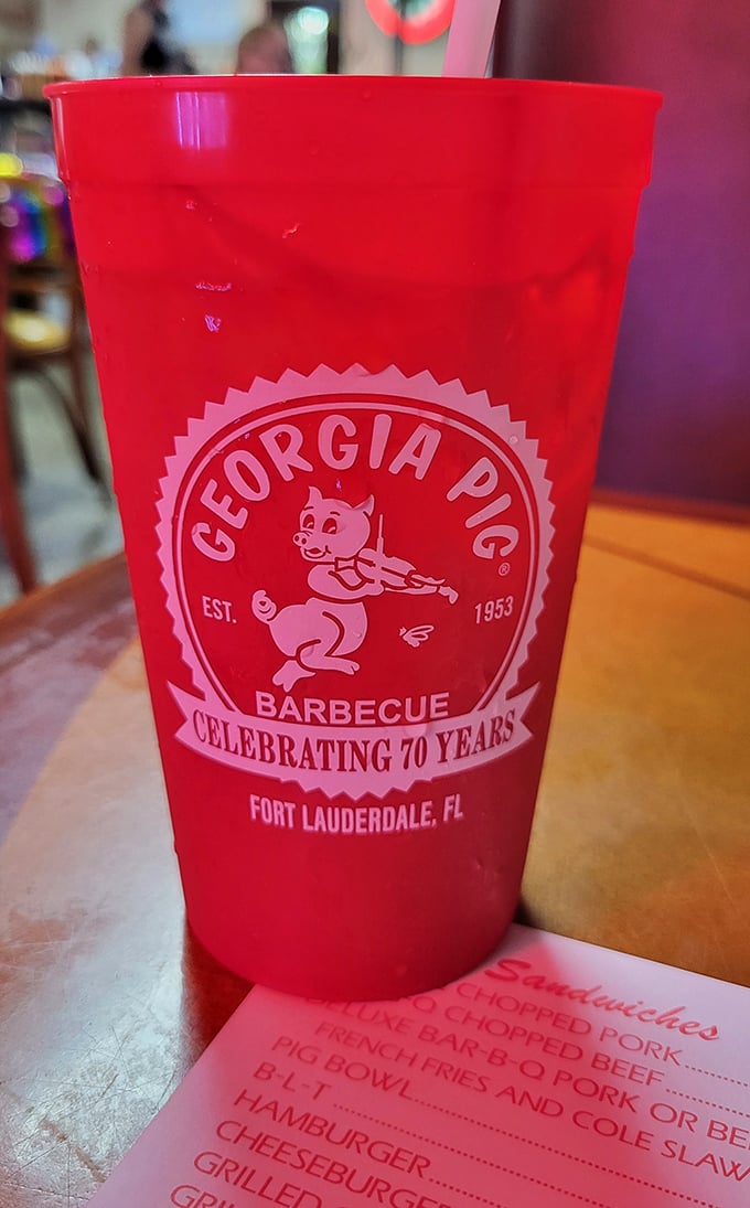 The cup says it all—70 years of barbecue excellence, with that fiddle-playing pig promising Southern hospitality in every sip.
